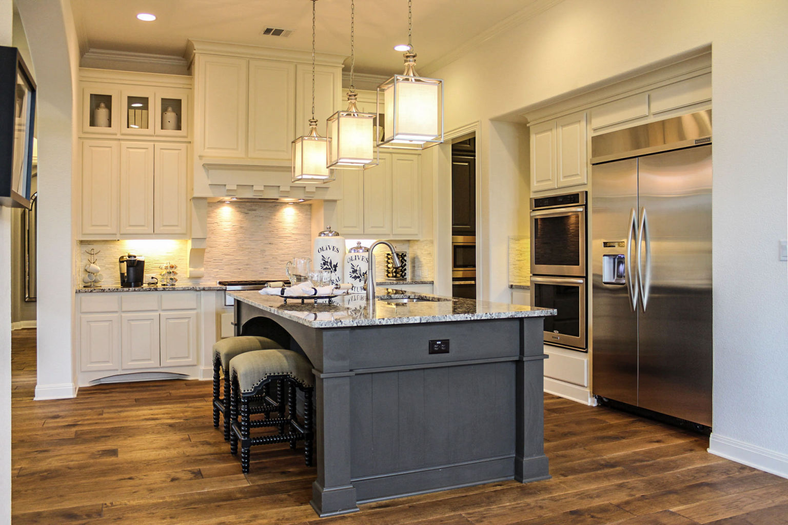 Kitchen cabinets in bone white with custom wood vent hood